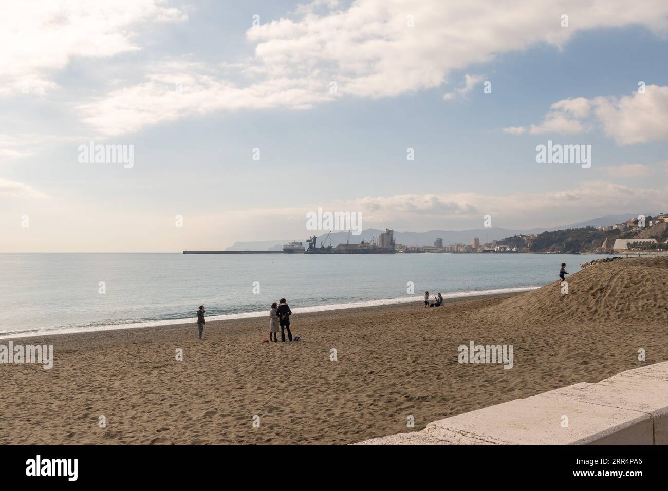 Scenic view of the off-season beach with people walking on the shore ...