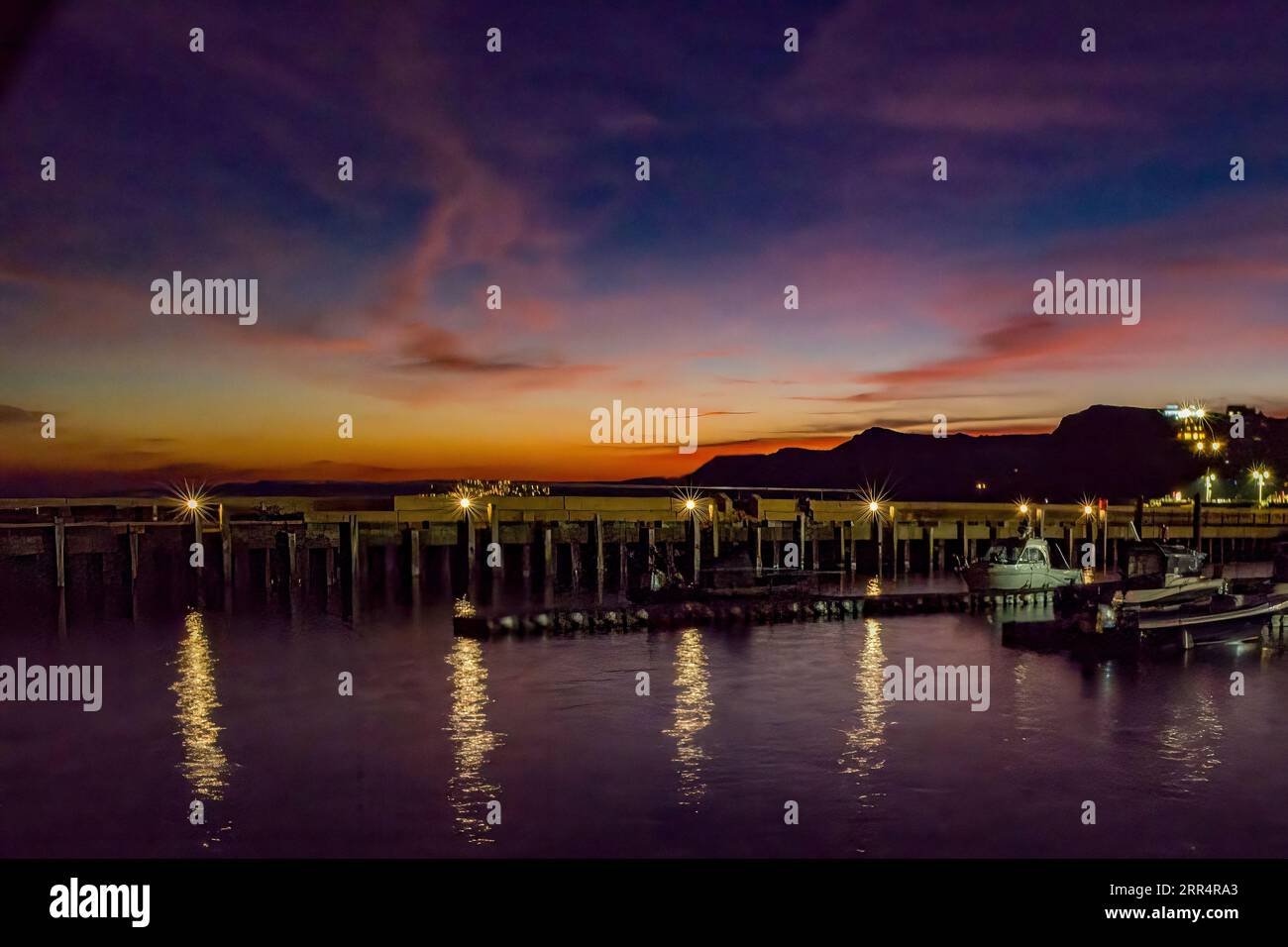 Swanage Bay and Pier at sunset, Dorset. Summer. Lamp reflections ...