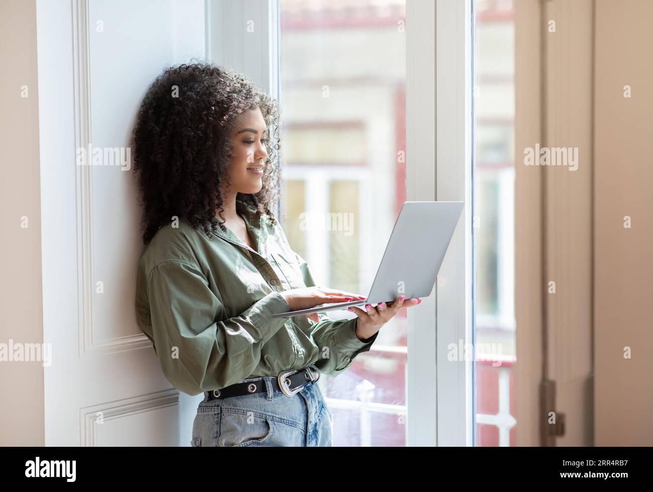 African Woman Working Online At Laptop Near Window At Home Stock Photo ...