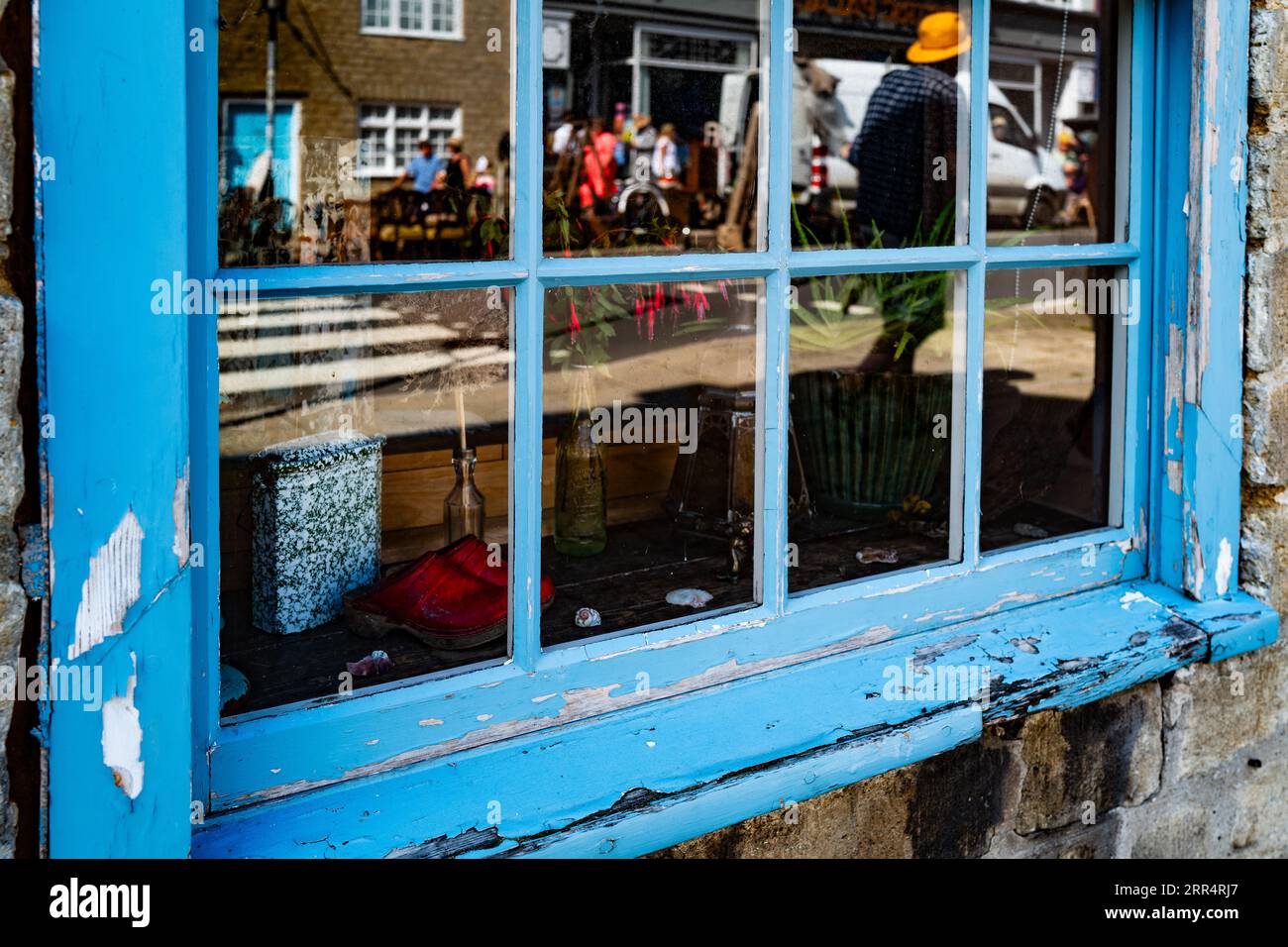 Antiques sitting behind a weathered blue house window frame. Concept of ...