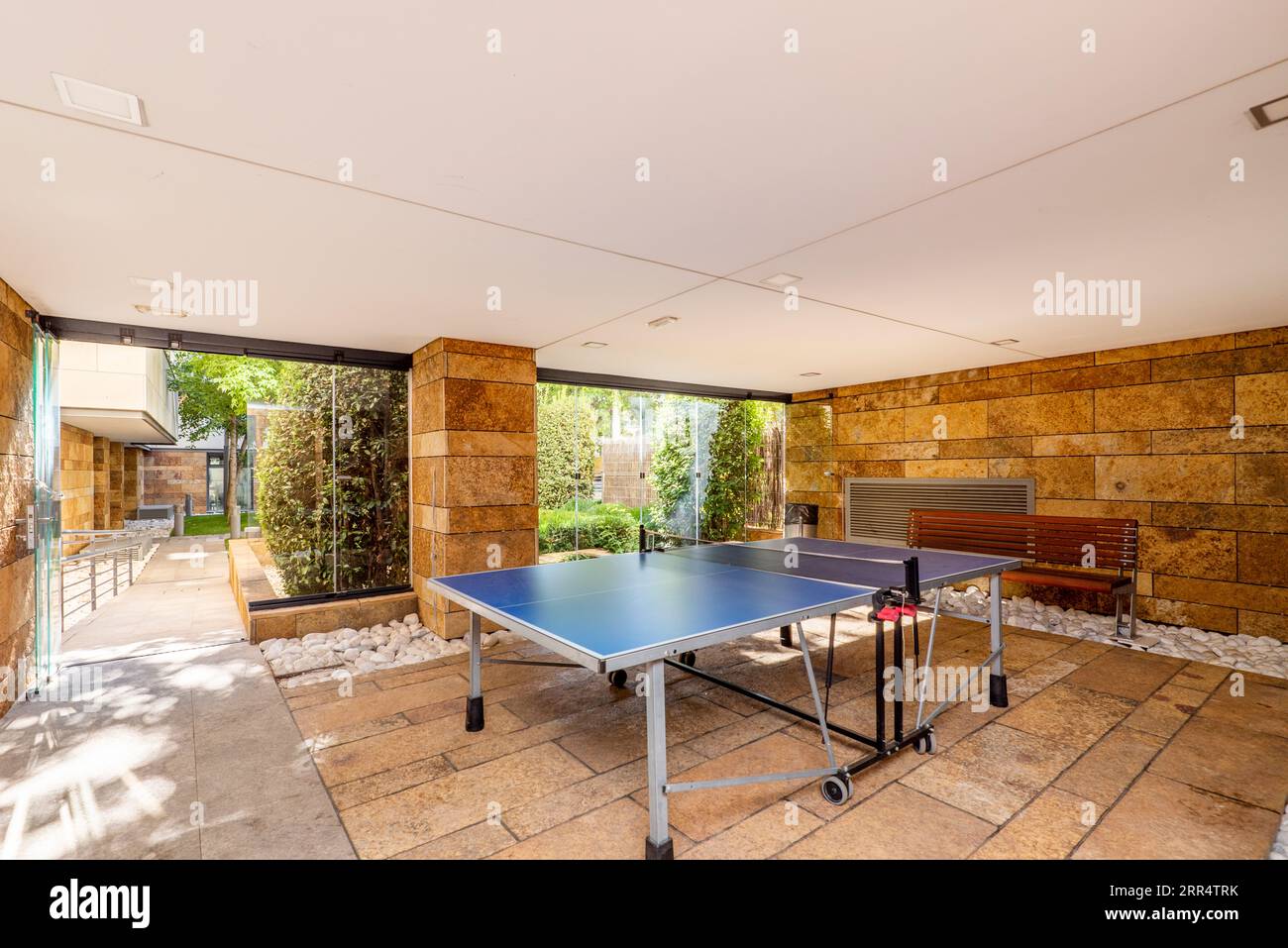 A folding ping pong table inside a room on the ground floor of a ...