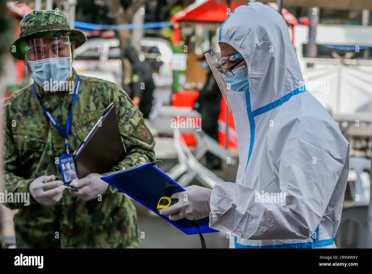 201215 -- QUEZON, Dec. 15, 2020 -- A policeman wearing personal ...