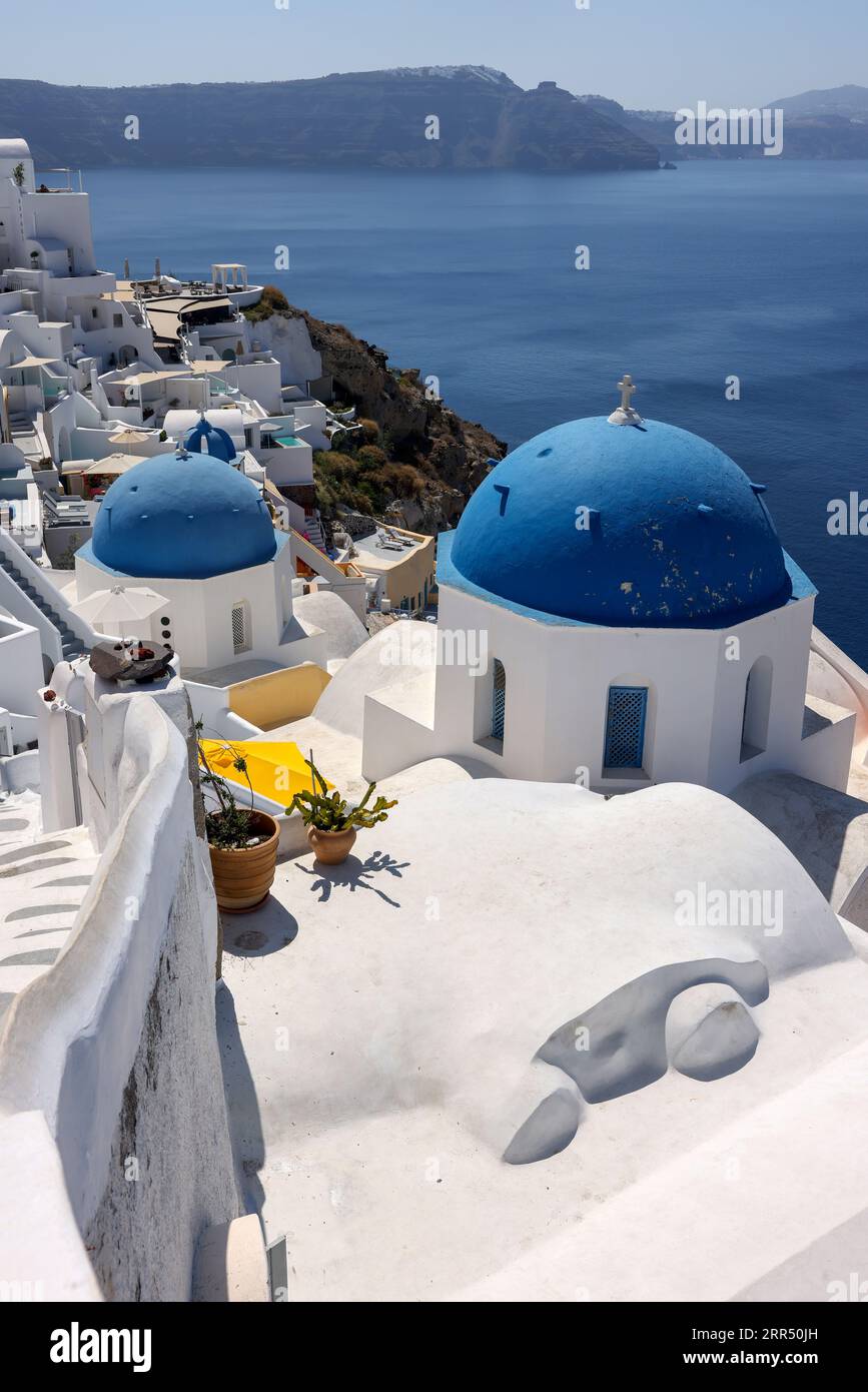 Whitewashed buildings on the edge of the caldera cliff in Oia village ...