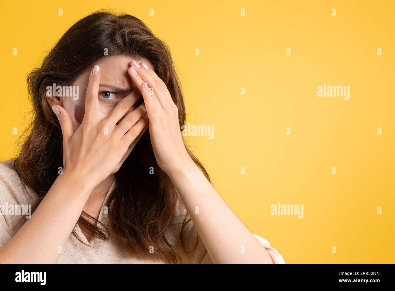 Scared young caucasian lady covers her face with hands, afraid ...