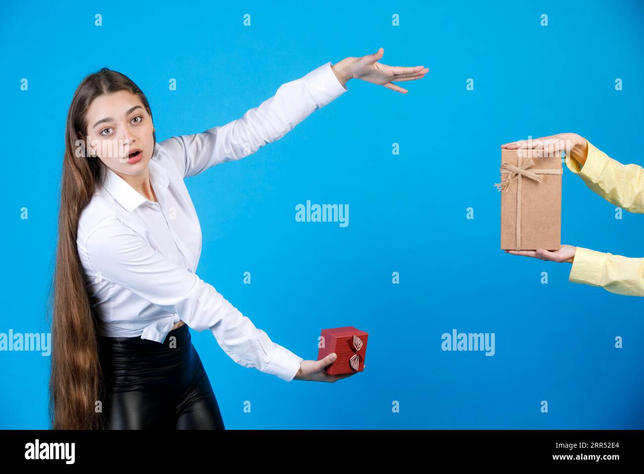 Surprised girl with tiny box displaying invisible size, while crop male ...
