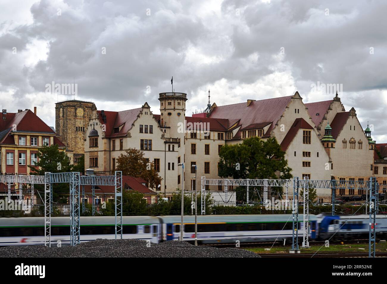 Railway tracks with electric traction and historic buildings with ...