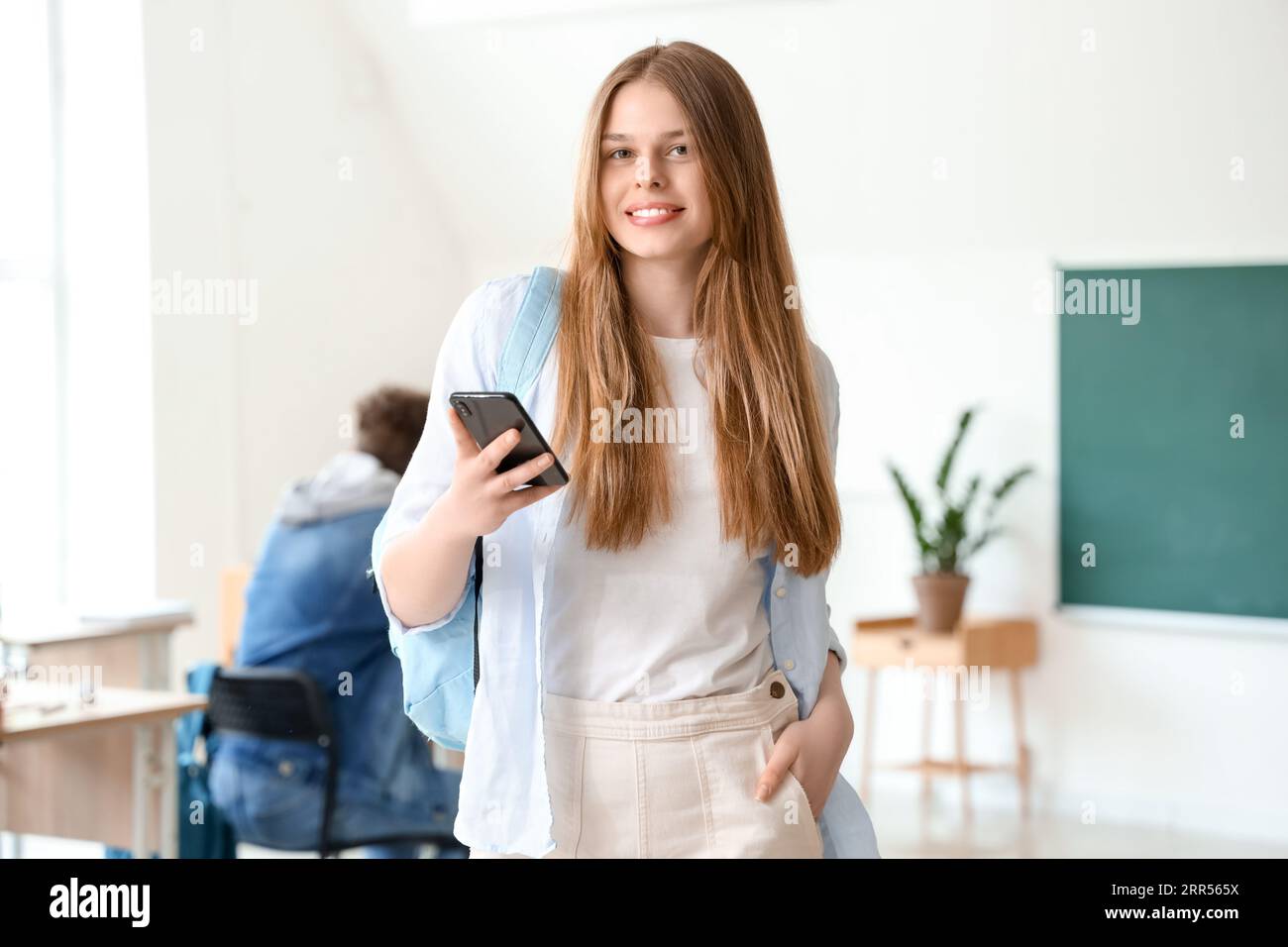 Female student with mobile phone in classroom Stock Photo - Alamy