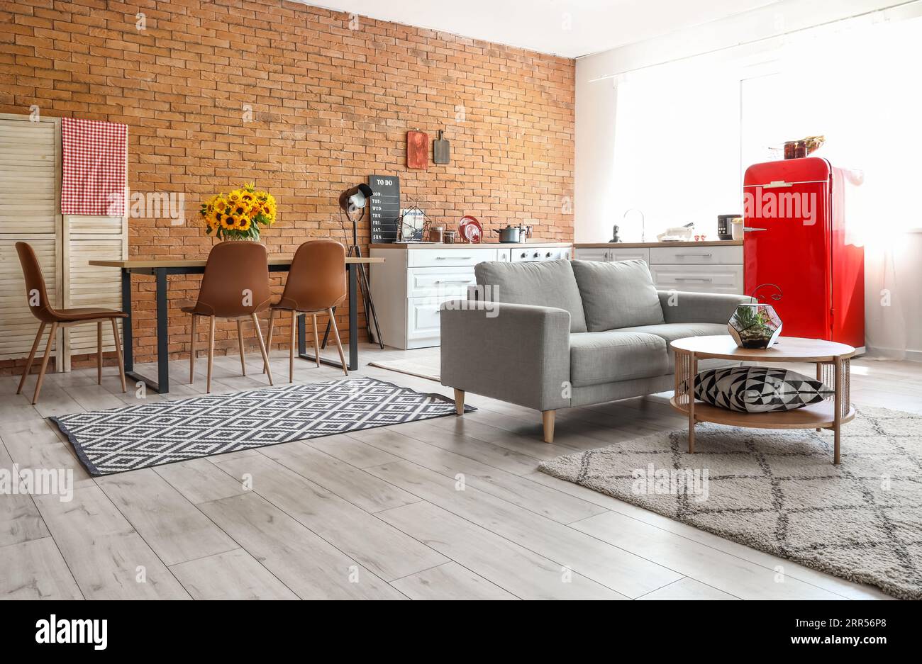 Interior of modern open space kitchen with grey sofa, coffee table and ...