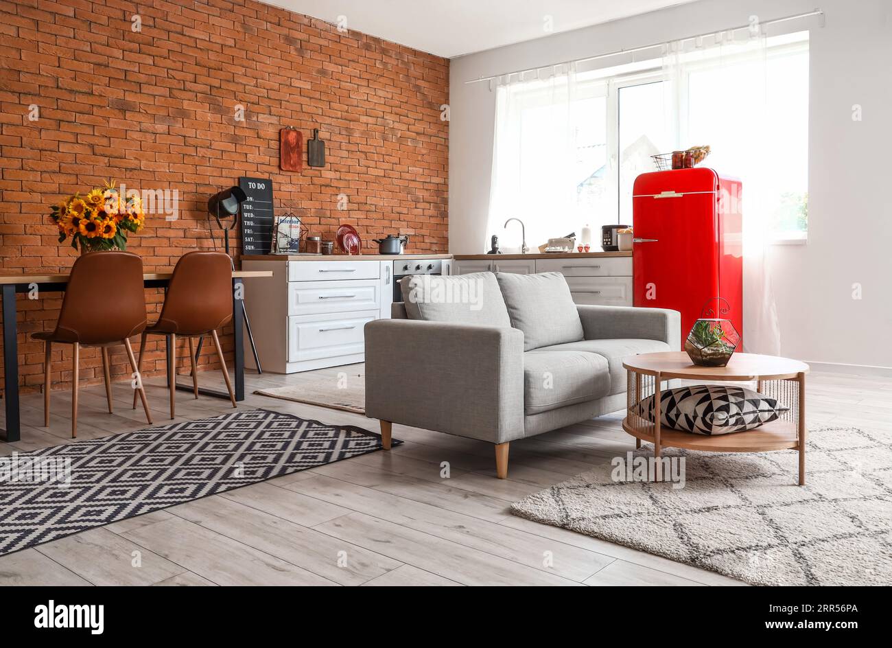 Interior of modern open space kitchen with grey sofa, coffee table and ...
