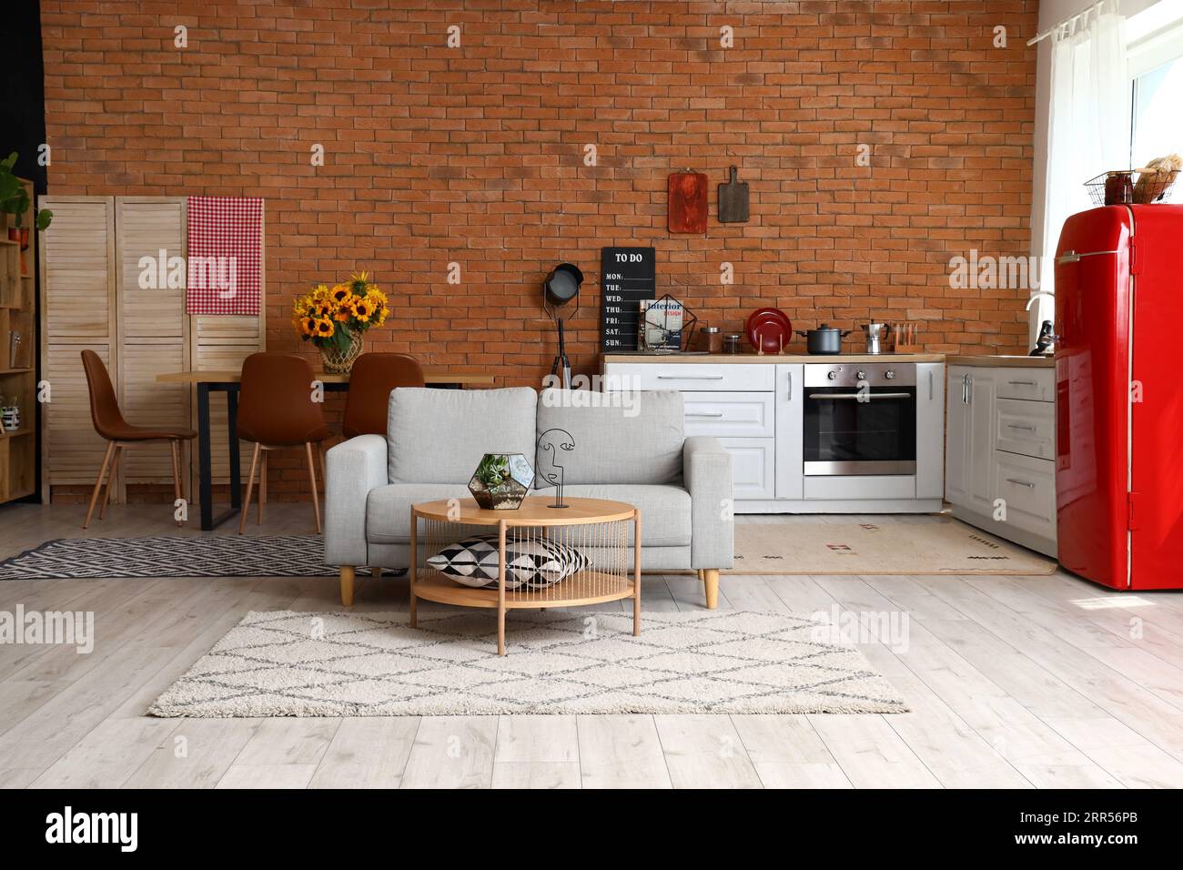 Interior of modern open space kitchen with grey sofa, coffee table and ...