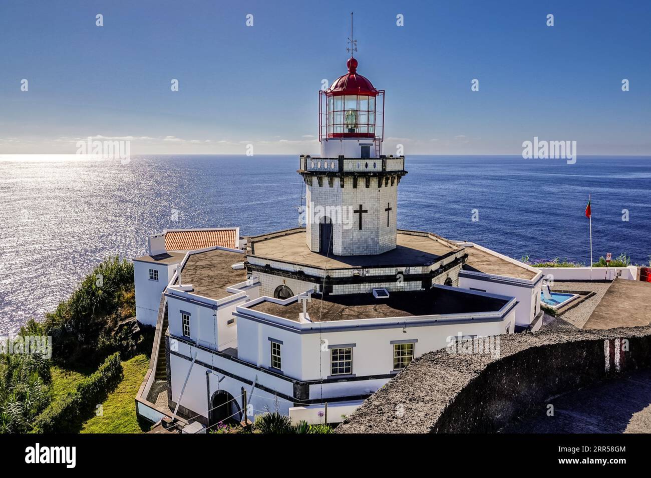 View of the historic Farol Ponta do Arnel lighthouse clinging to the ...