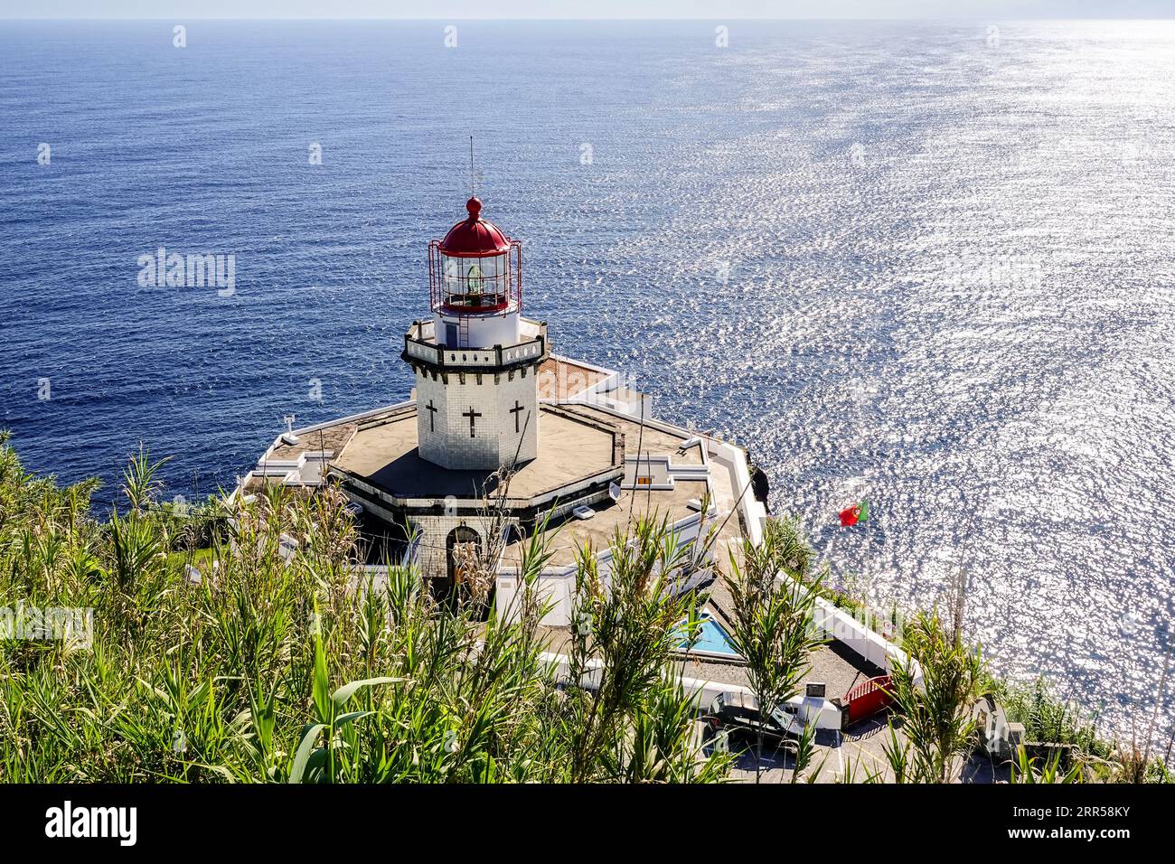 View of the historic Farol Ponta do Arnel lighthouse clinging to the ...