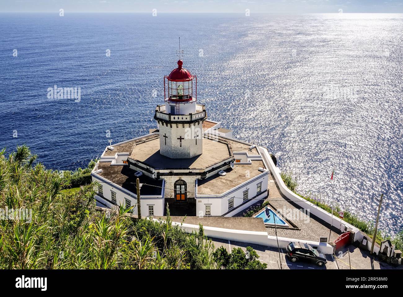 View of the historic Farol Ponta do Arnel lighthouse clinging to the ...