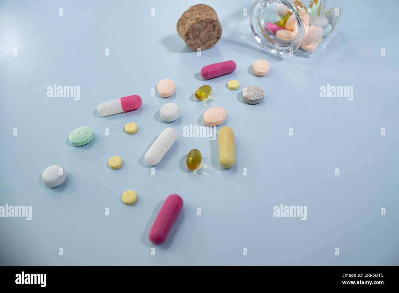 many pills scattered on surface or from bottle in woman hand palm ...