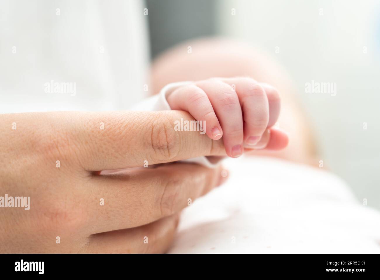 Newborn finds solace in mother's touch. Concept of unspoken promises ...