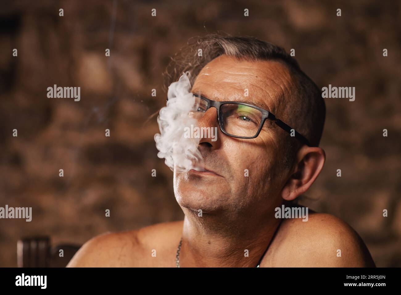 A satisfied older man, sixty years old, smokes thoughtfully Stock Photo ...