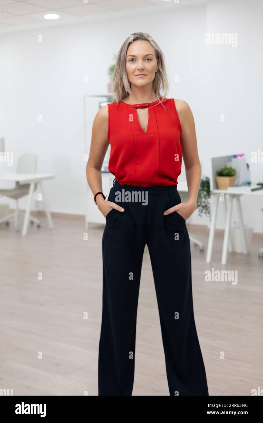 Portrait of beautiful executive woman in red blouse and office ...