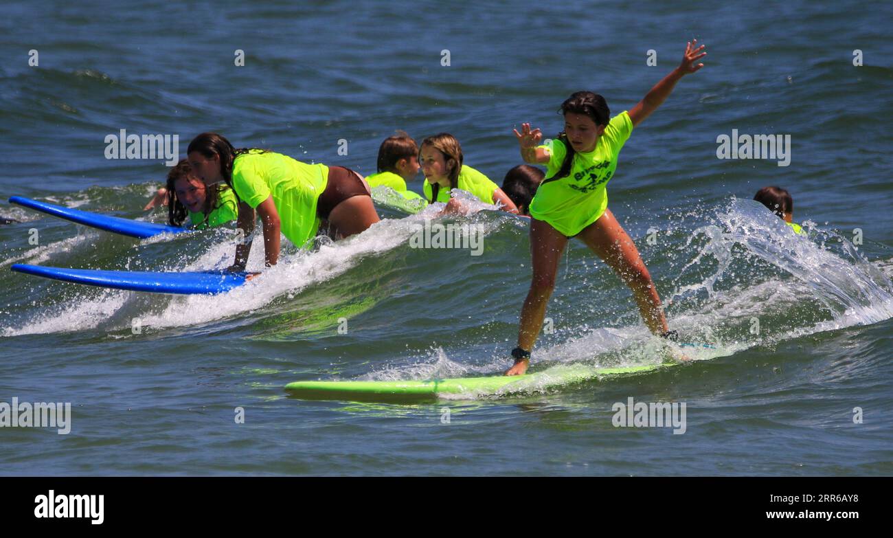 Gilgo Beach, New York, USA - 25 July 2023: Kids in neon green shirts ...