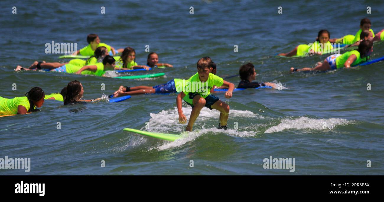 Gilgo Beach, New York, USA - 25 July 2023: Kids in neon green shirts ...