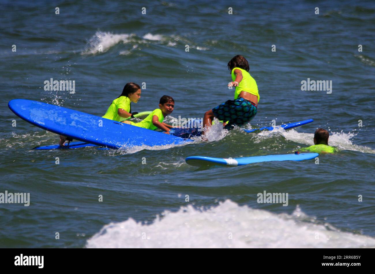 Gilgo Beach, New York, USA - 25 July 2023: Kids in neon green shirts ...