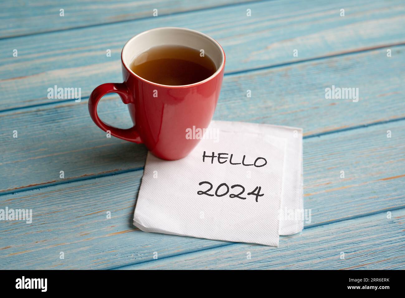 Hello 2024 on piece of tissue next to a red cup of coffee Stock Photo ...