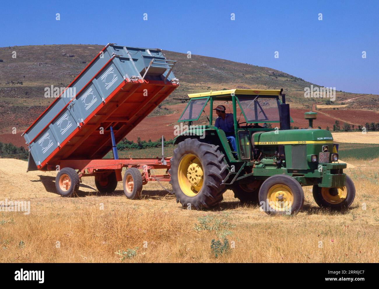 TRACTOR CON REMOLQUE DEJANDO LA CEBADA EN LA ERA. Location: EXTERIOR ...