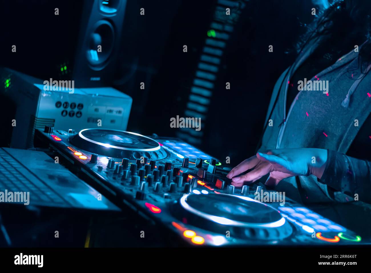 Close up of DJ hands playing various track controls on the DJ mixing ...
