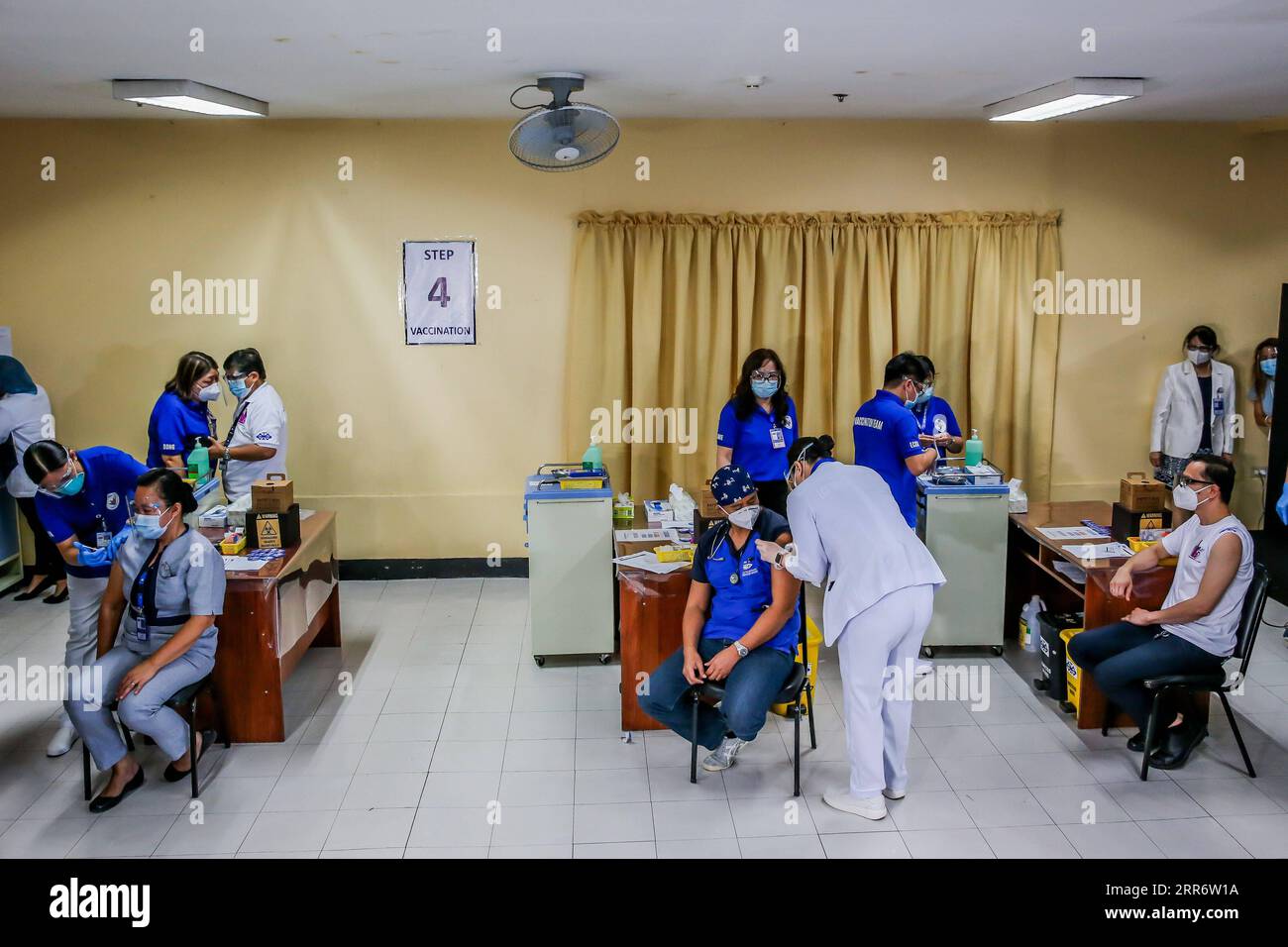 210301 -- MANILA, March 1, 2021 -- Health workers receive the COVID-19 ...