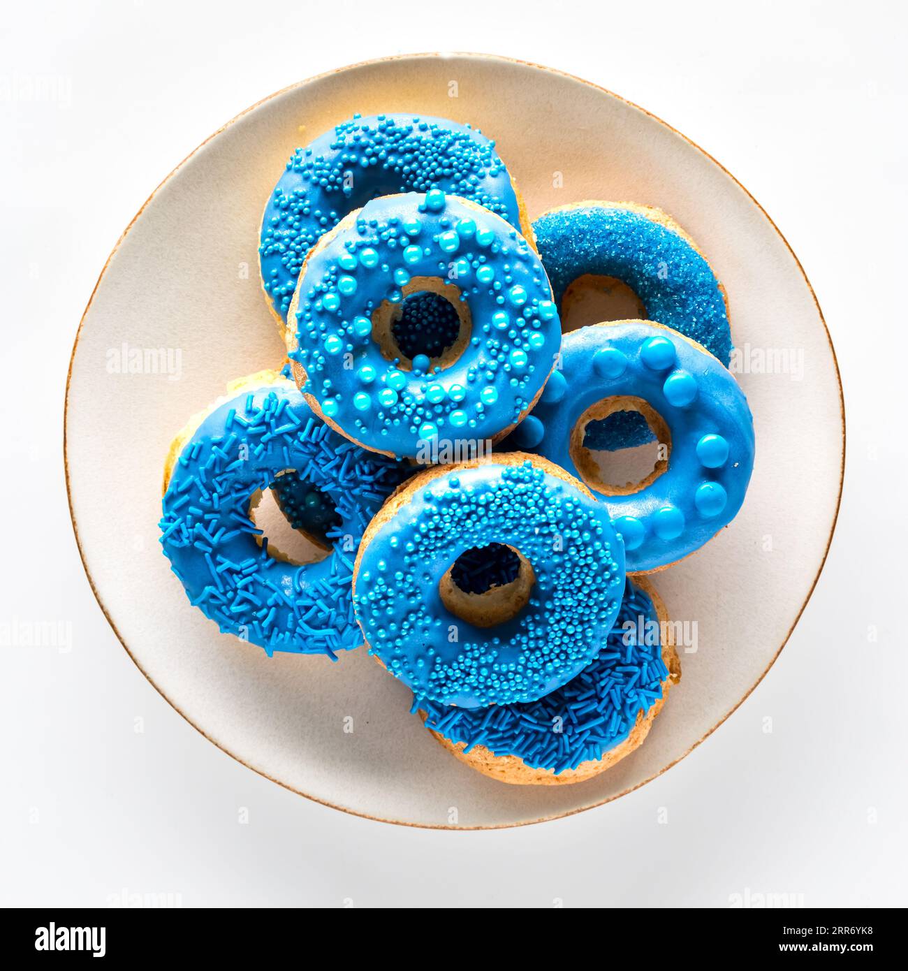 A plate topped with a pile of decorated blue donuts Stock Photo - Alamy