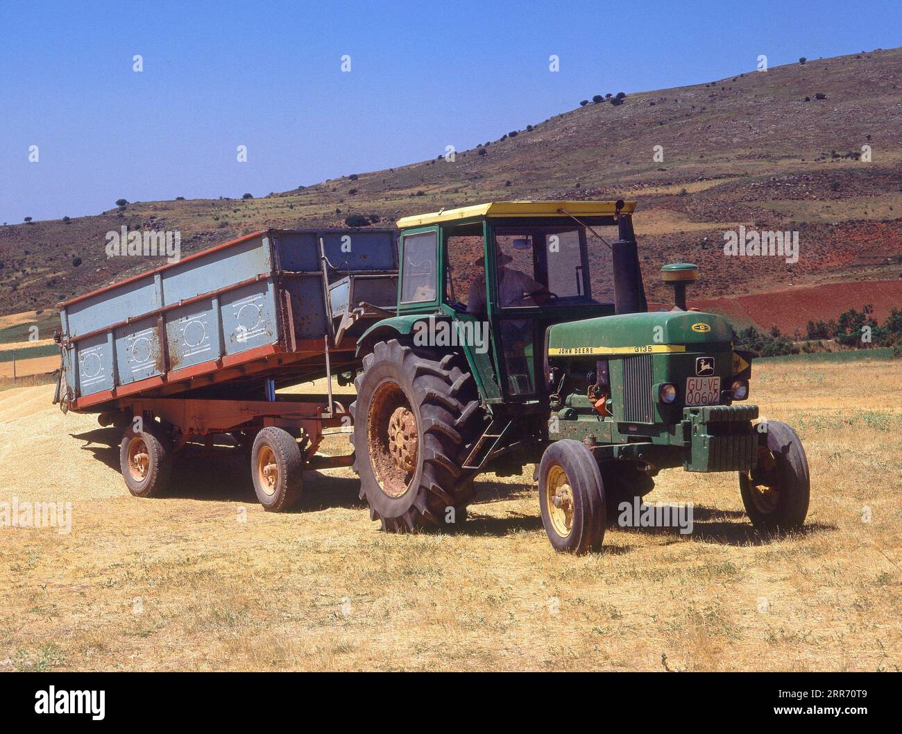 TRACTOR CON REMOLQUE DEJANDO LA CEBADA EN LA ERA. Location: EXTERIOR ...