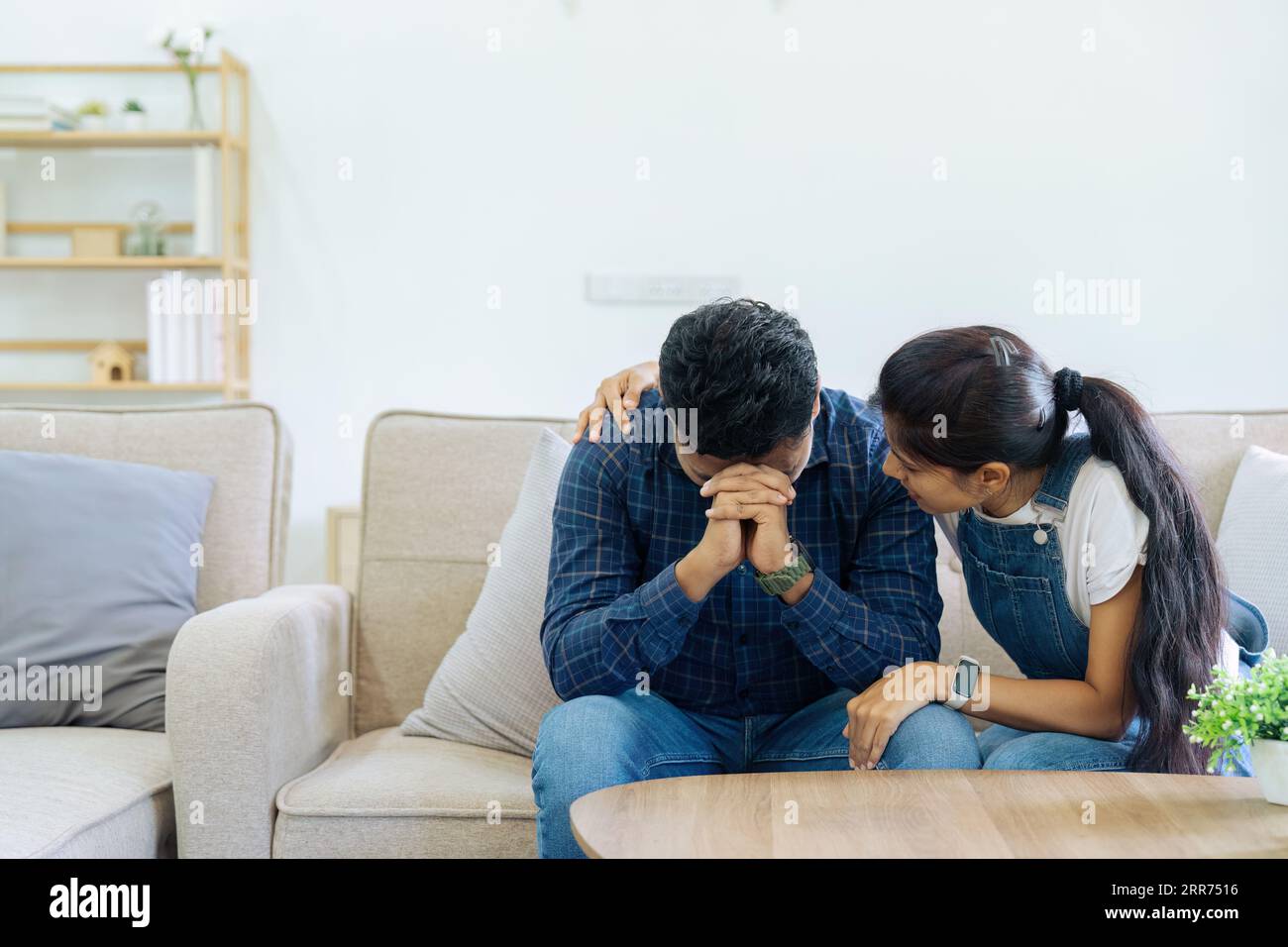 Compassionate wife giving comfort and support to husband who is worried ...