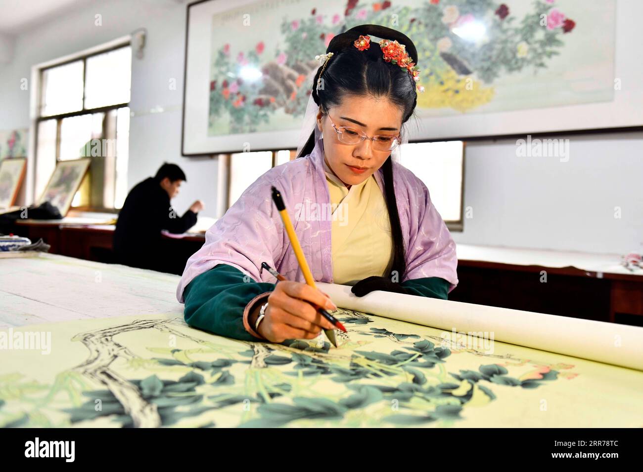 210320 -- JUYE, March 20, 2021 -- A worker draws a peony-themed ...