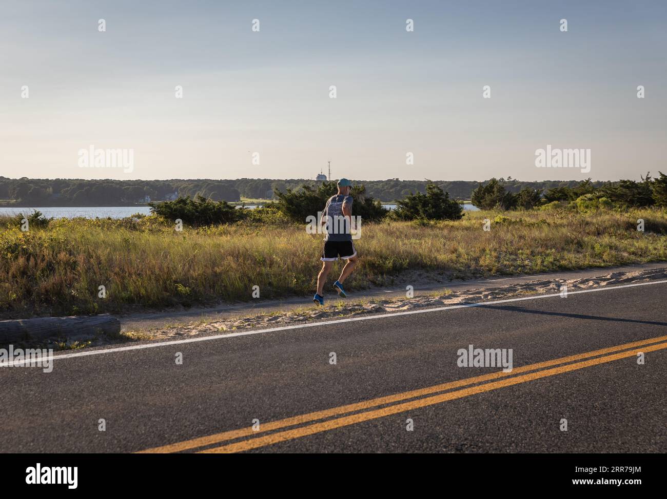 A man running along the shoreline of Martha's Vineyard on a clear ...