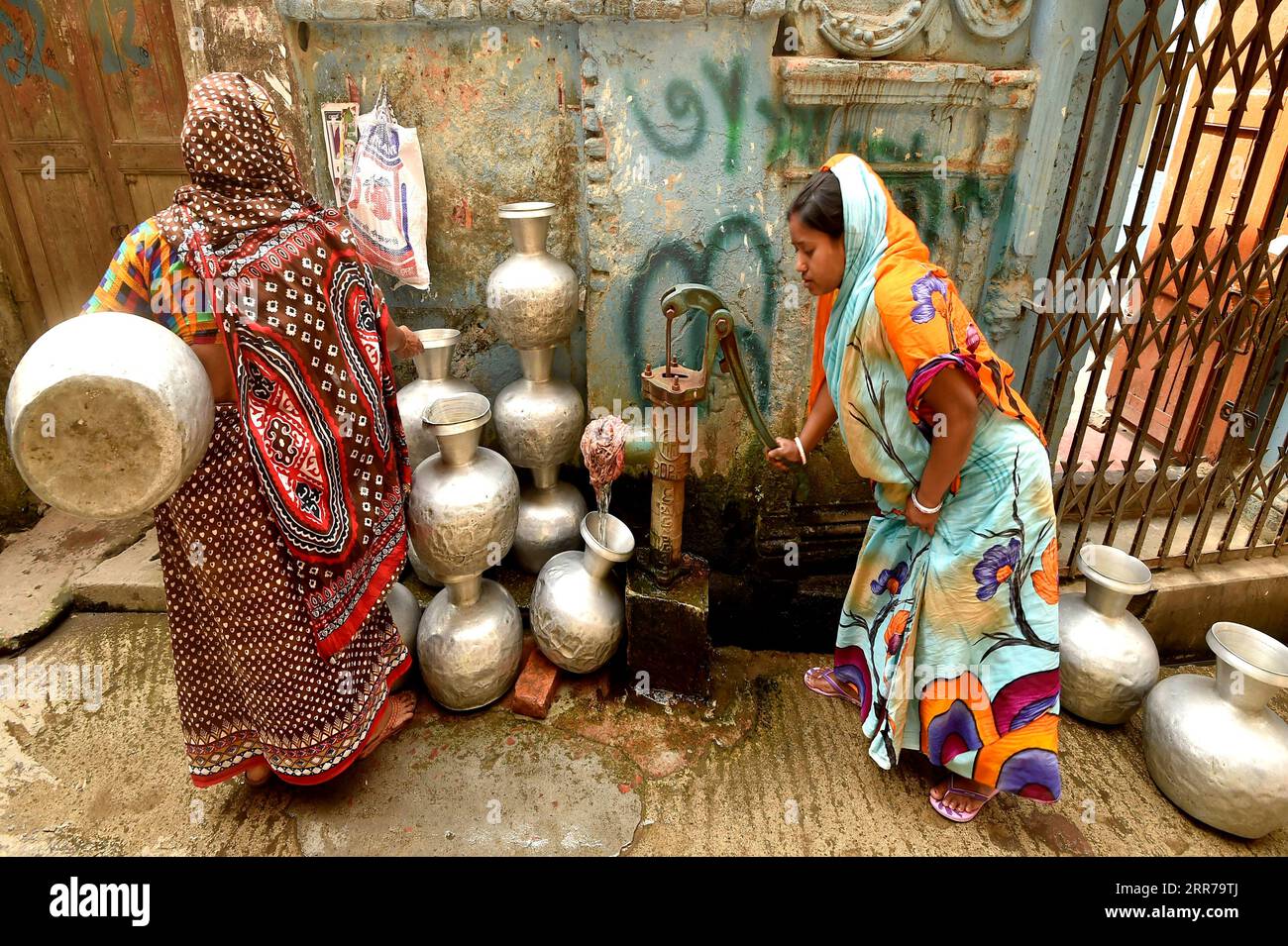 210322 -- DHAKA, March 22, 2021 -- Women collect water from a tube well ...