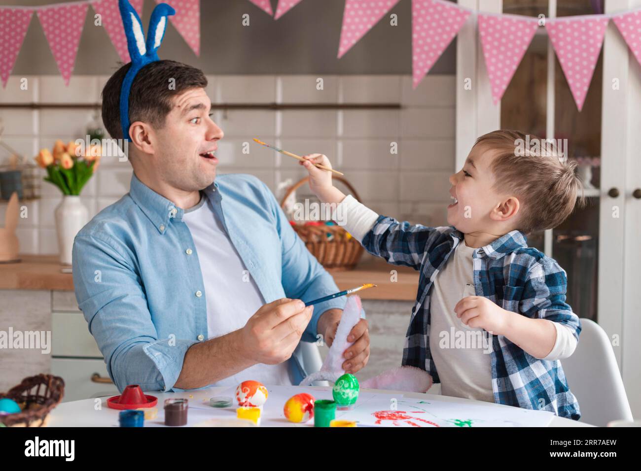Adorable little boy trying paint his father Stock Photo - Alamy