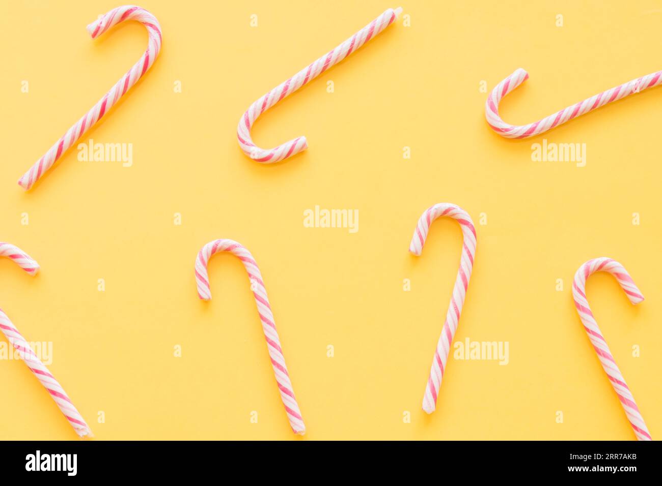 Christmas candy canes yellow background Stock Photo - Alamy