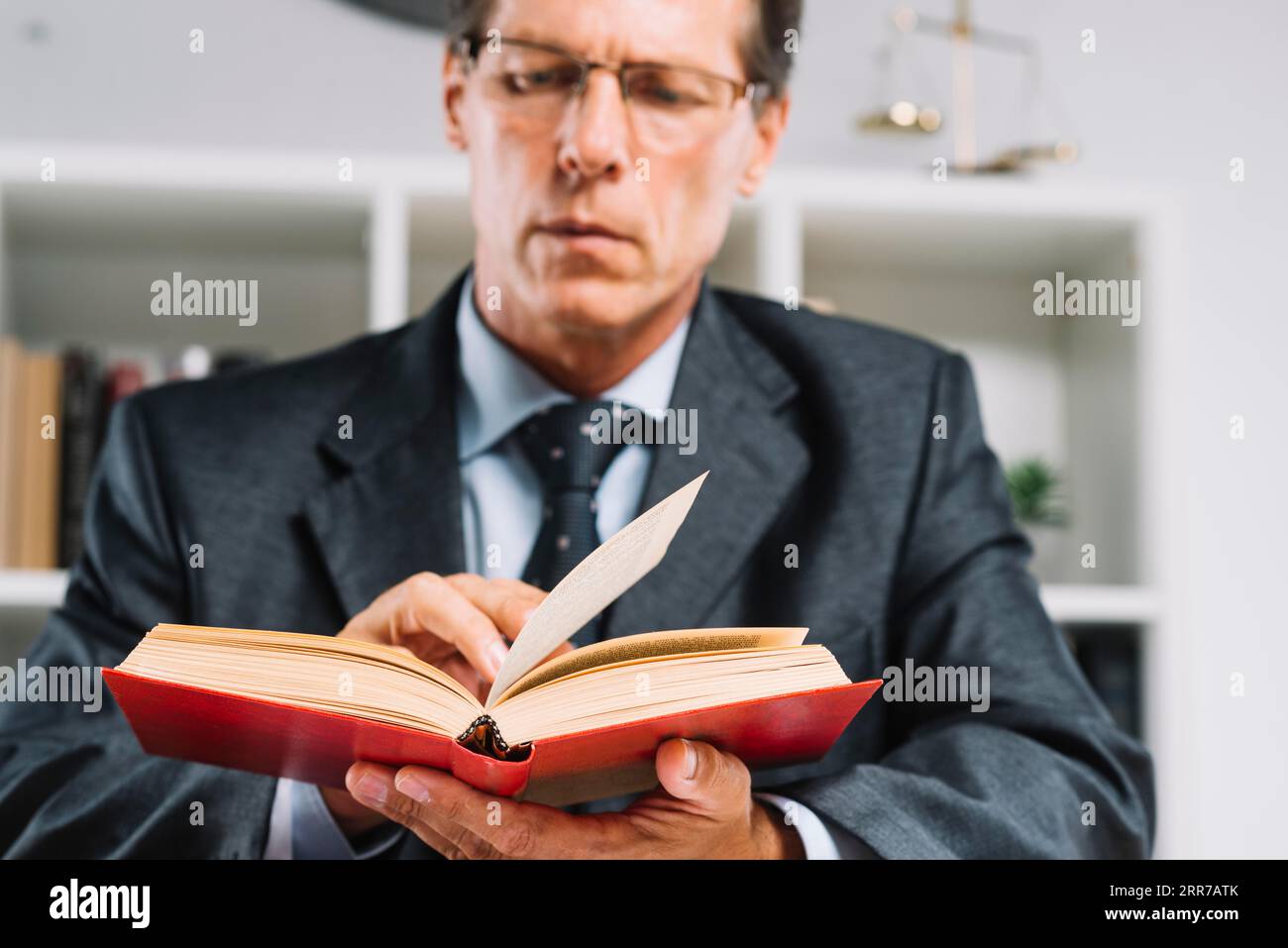 Mature male judge reading book courtroom Stock Photo - Alamy