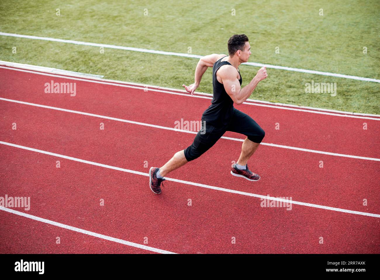 Male athlete arrives finish line racetrack during training session ...