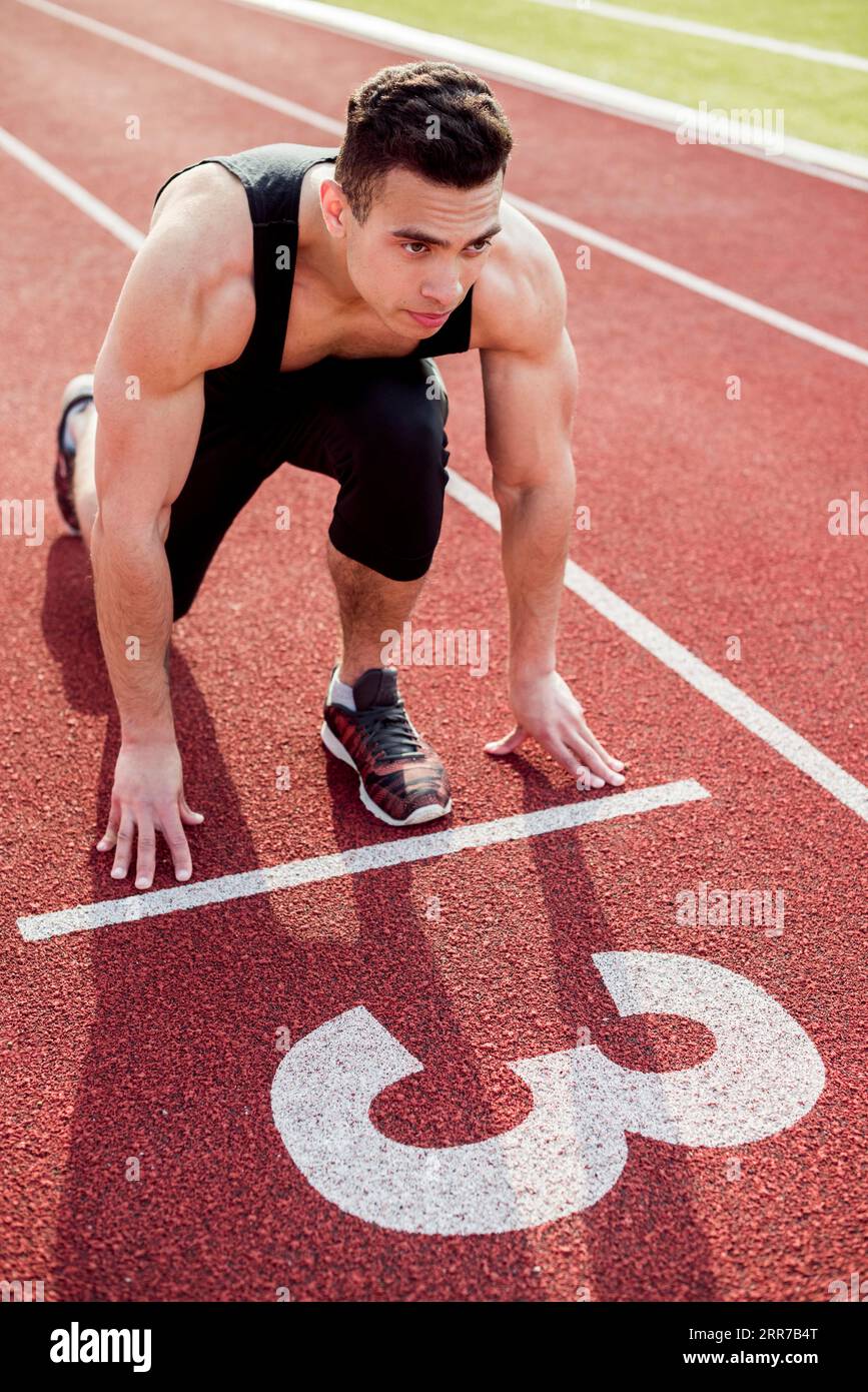 Muscular male young runner start line Stock Photo - Alamy