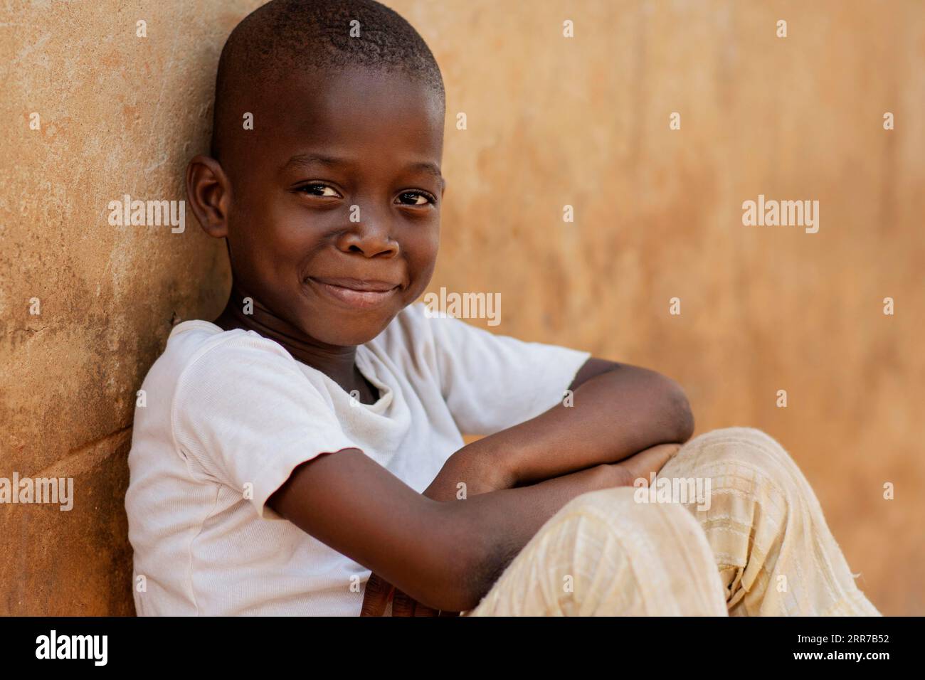 Medium shot smiley kid sitting outdoors Stock Photo - Alamy
