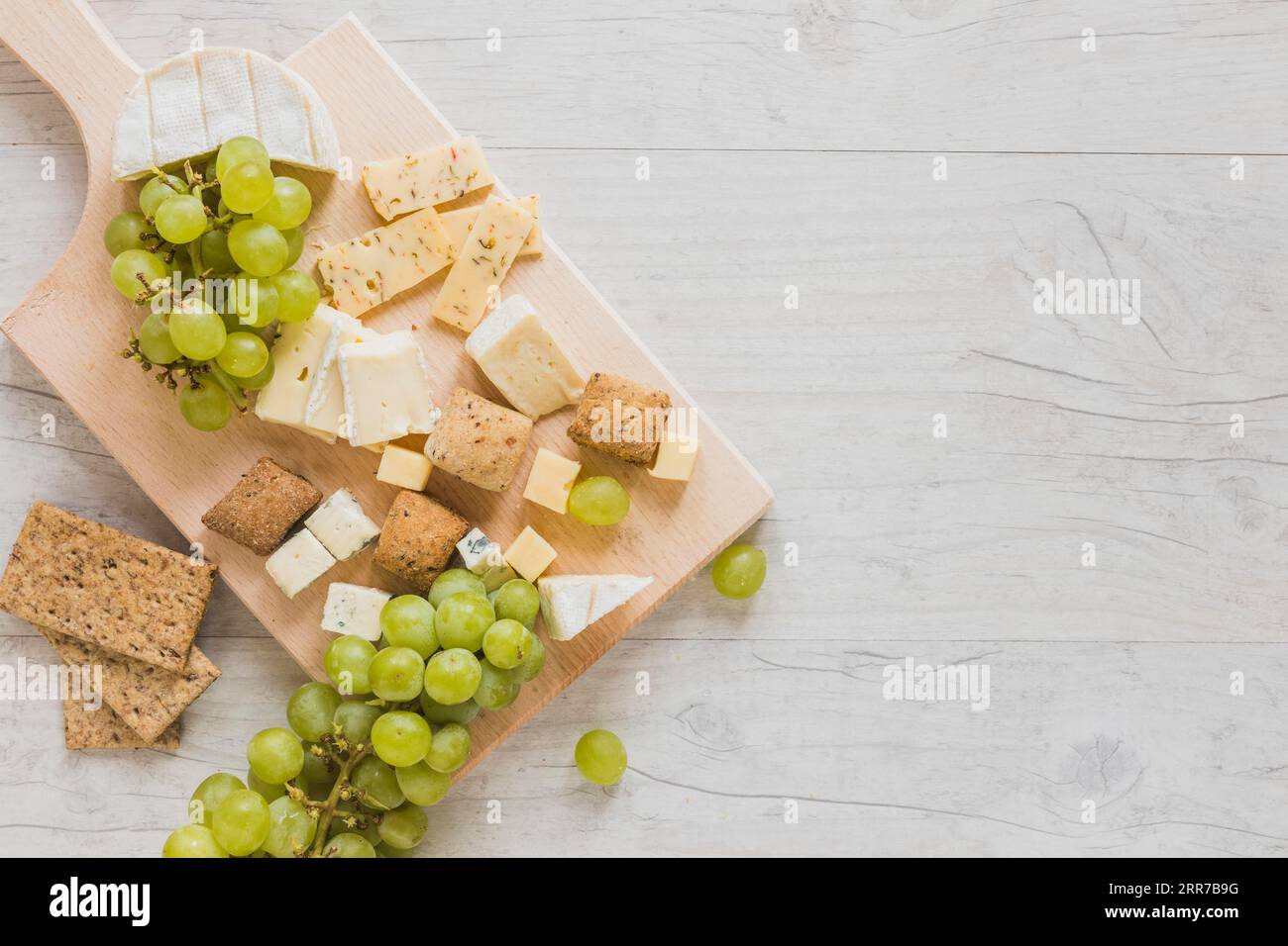 Overhead view cheese blocks crisp bread grapes wooden desk Stock Photo ...