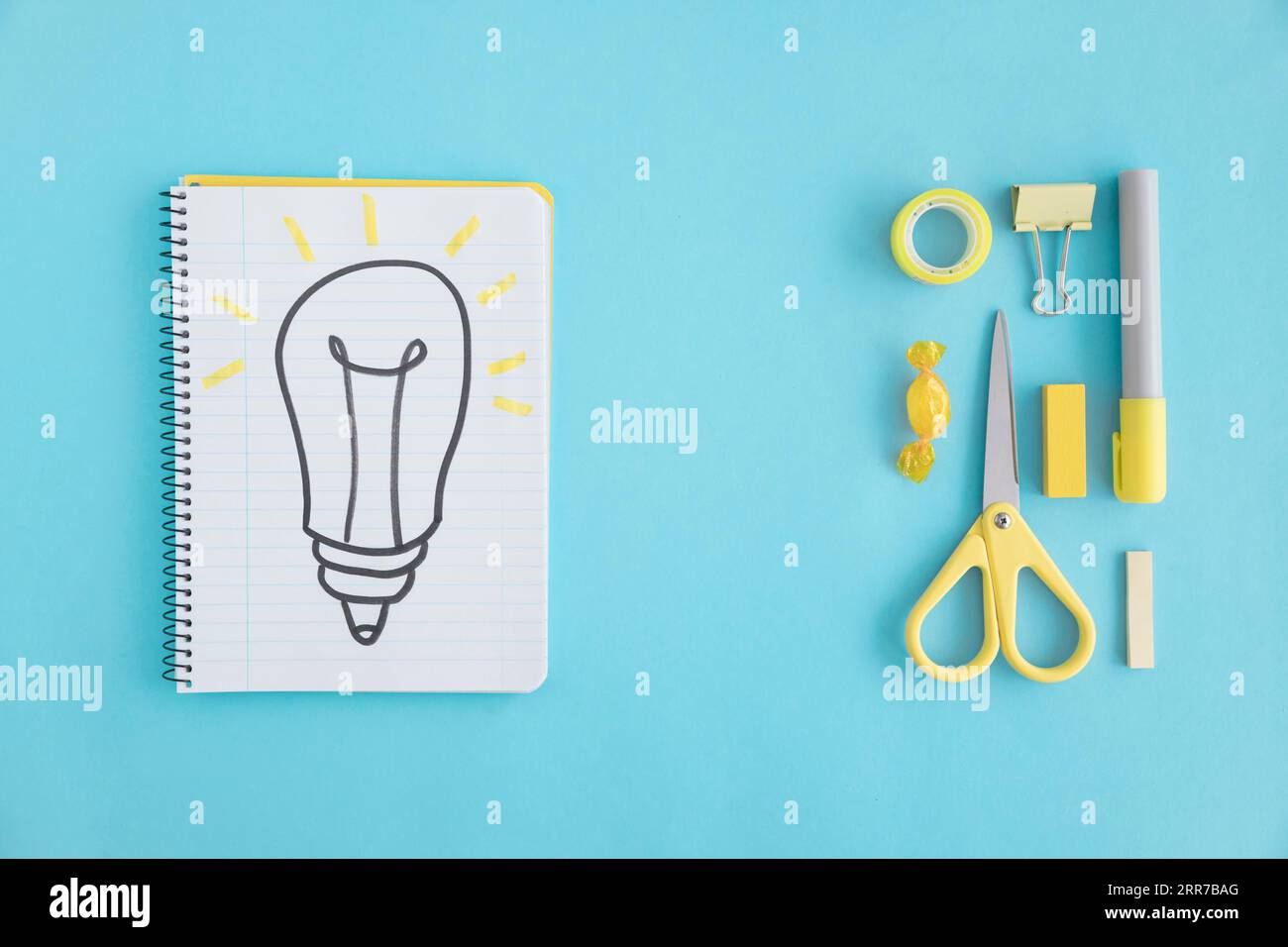 Overhead view hand drawn light bulb notebook with stationary blue ...