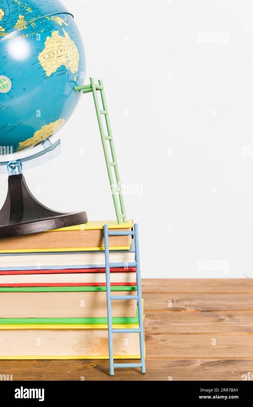 Paper ladder terrestrial global map stand ball books wooden table Stock ...