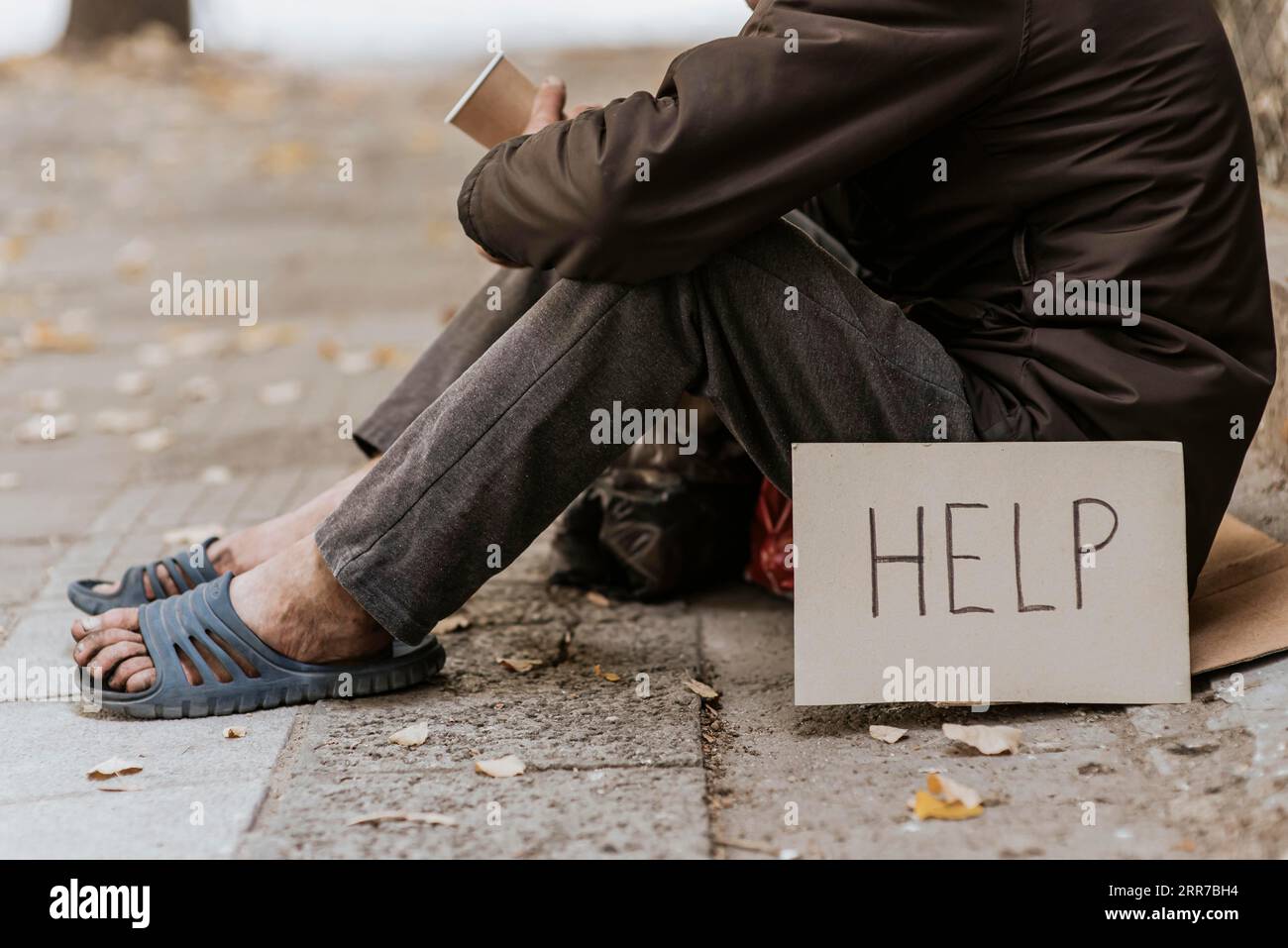 Side view homeless man street with cup help sign Stock Photo - Alamy