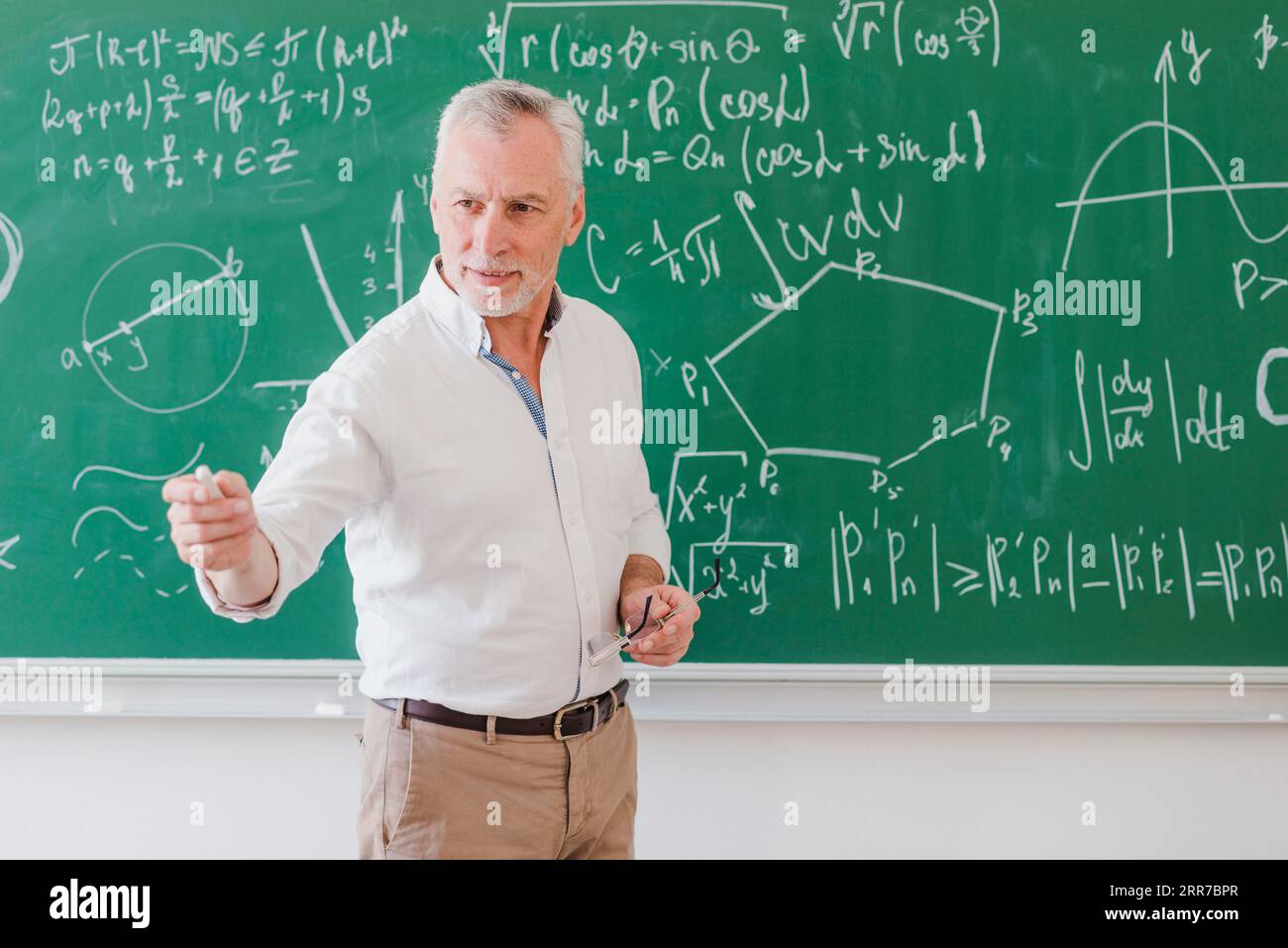 Sociable male teacher standing blackboard pointing by hand Stock Photo ...