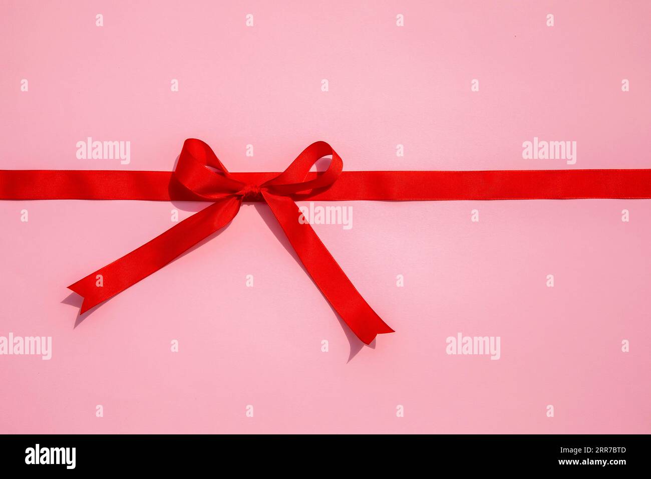 Simplistic red ribbon with bow Stock Photo - Alamy