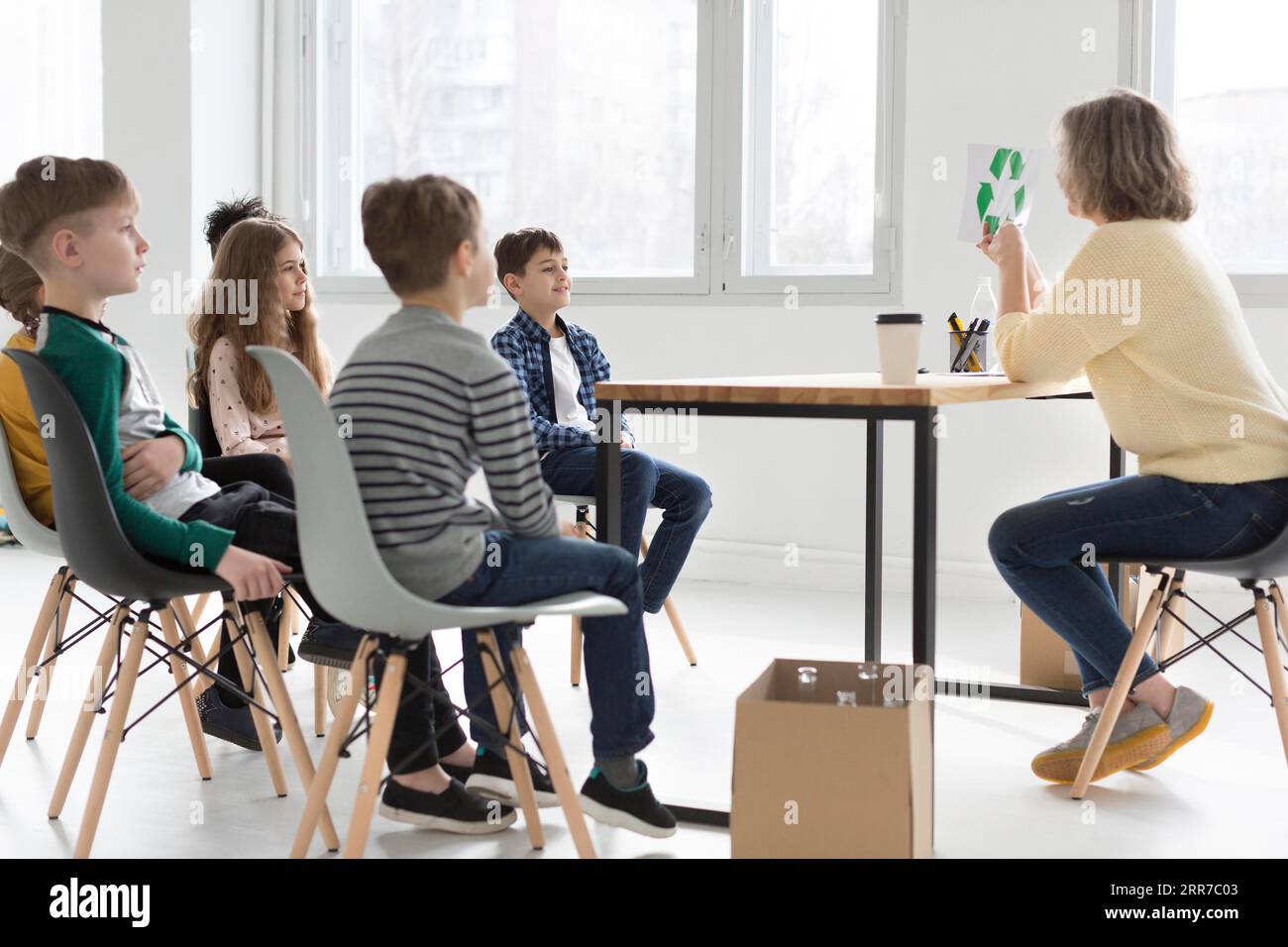 Teacher showing children how recycle Stock Photo - Alamy