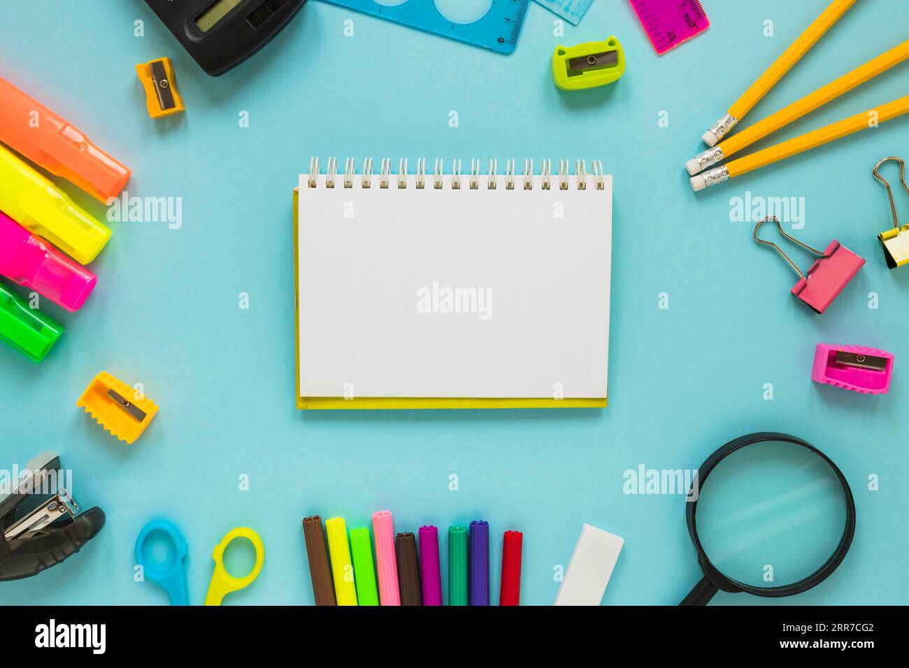 Writing implements laid circle with jotter middle Stock Photo - Alamy
