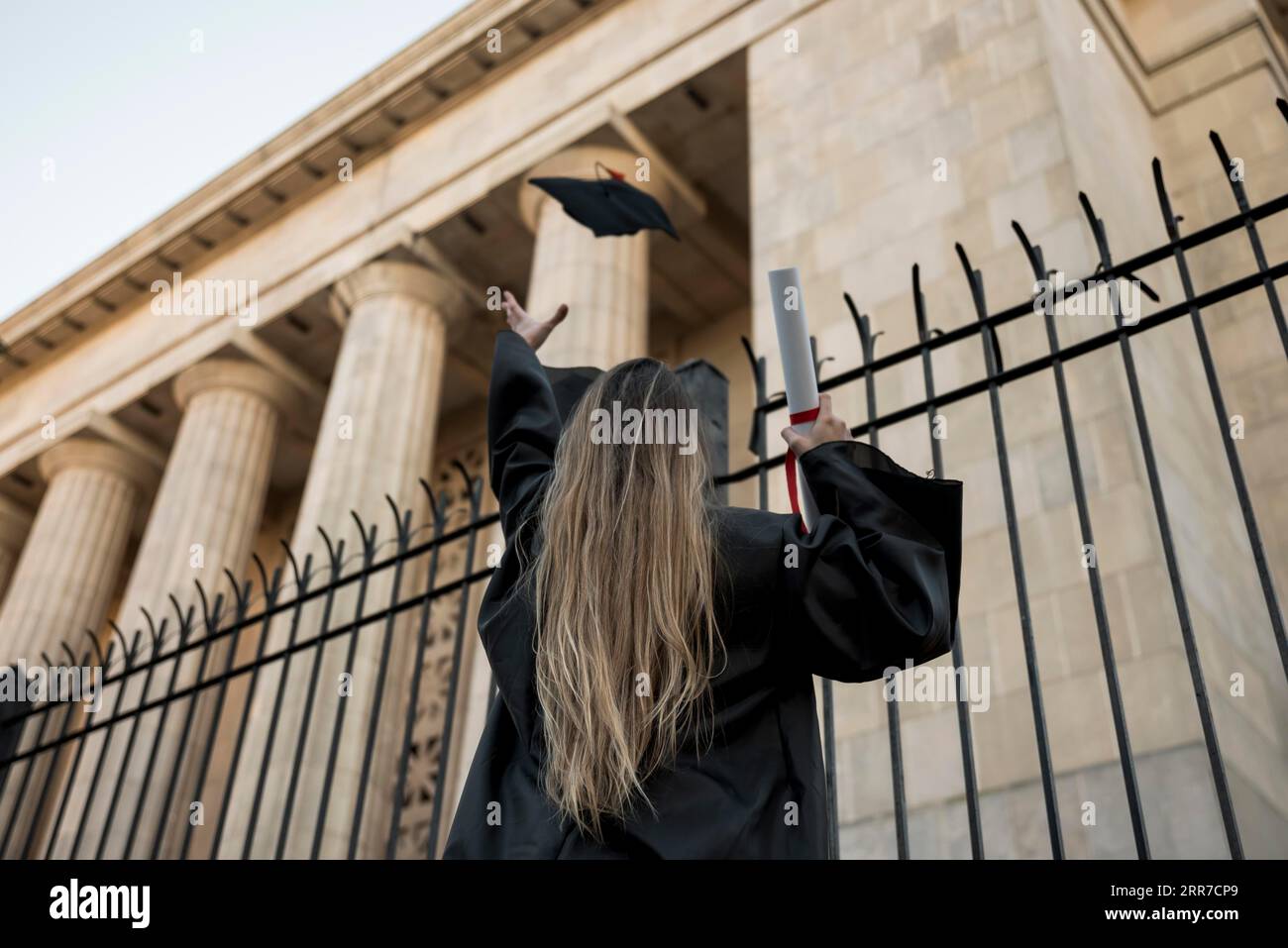Back view girl throwing her trencher Stock Photo - Alamy