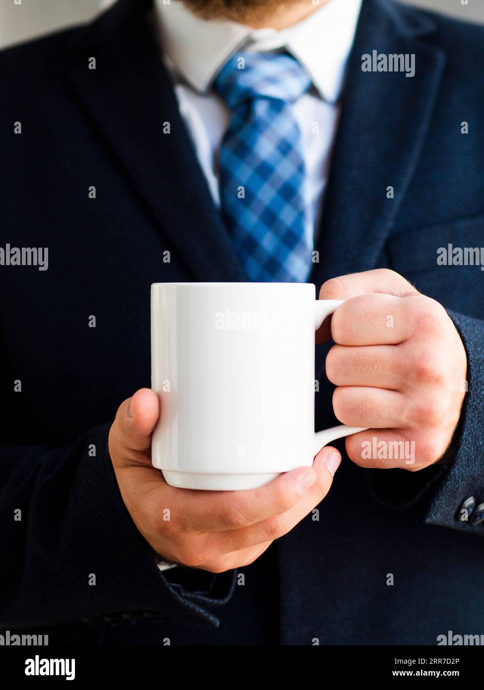 Elegant man holding up mug Stock Photo - Alamy